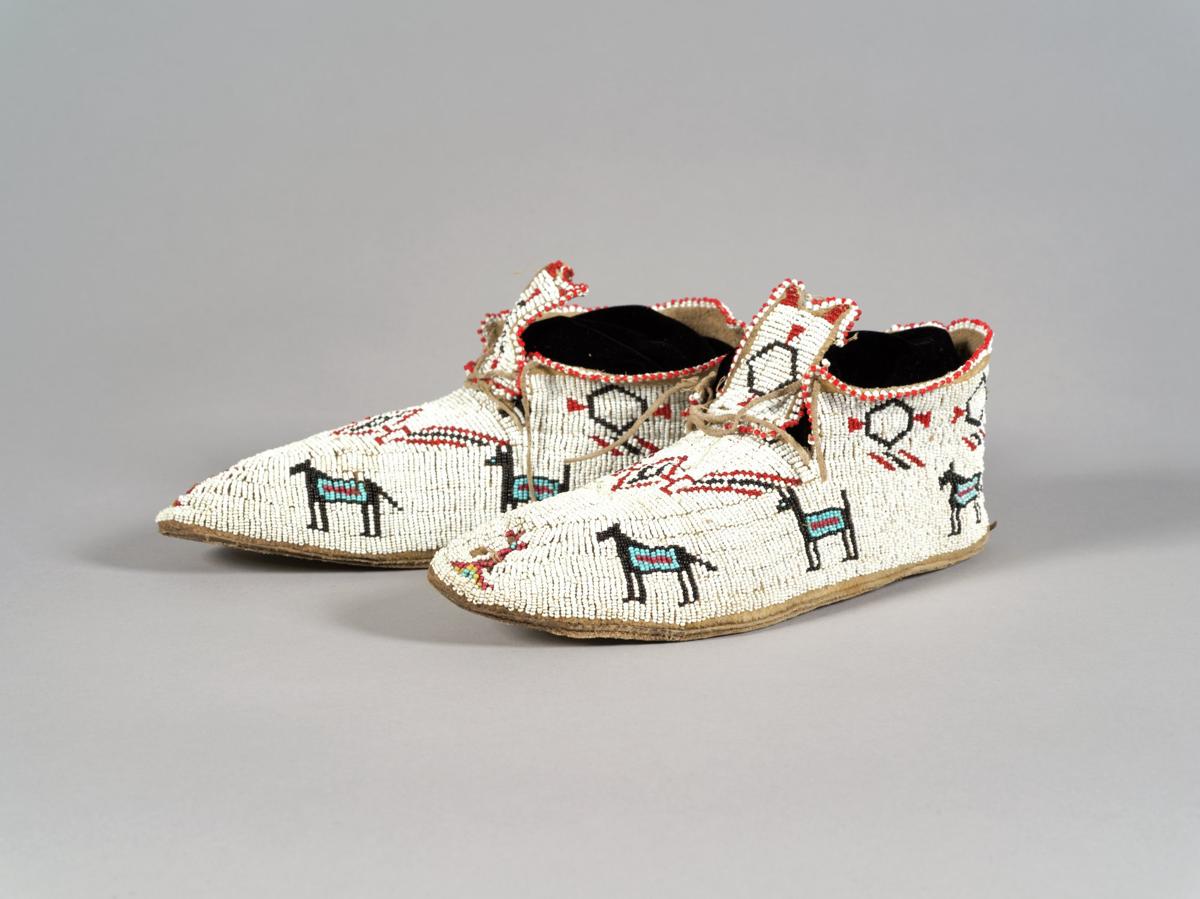 Woman's semi-tanned leather moccasins with beaded cuff and rosette